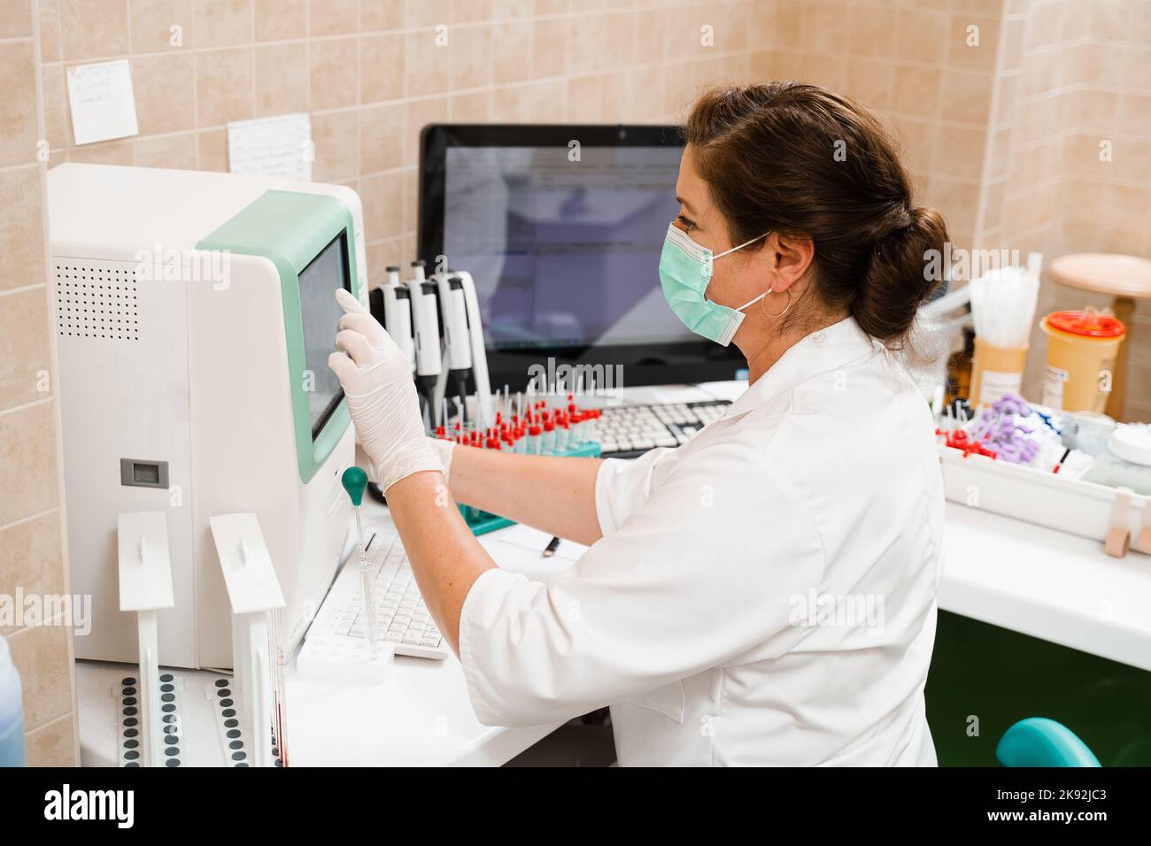 Laboratory assistant works on blood analyzer and makes hematological ...