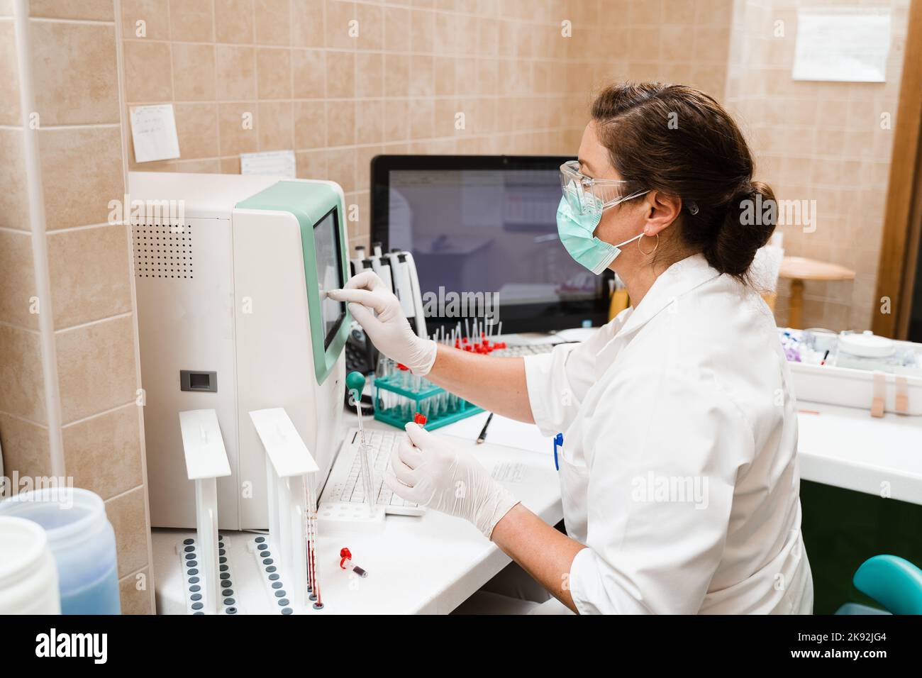 Laboratory assistant works on blood analyzer and makes hematological ...