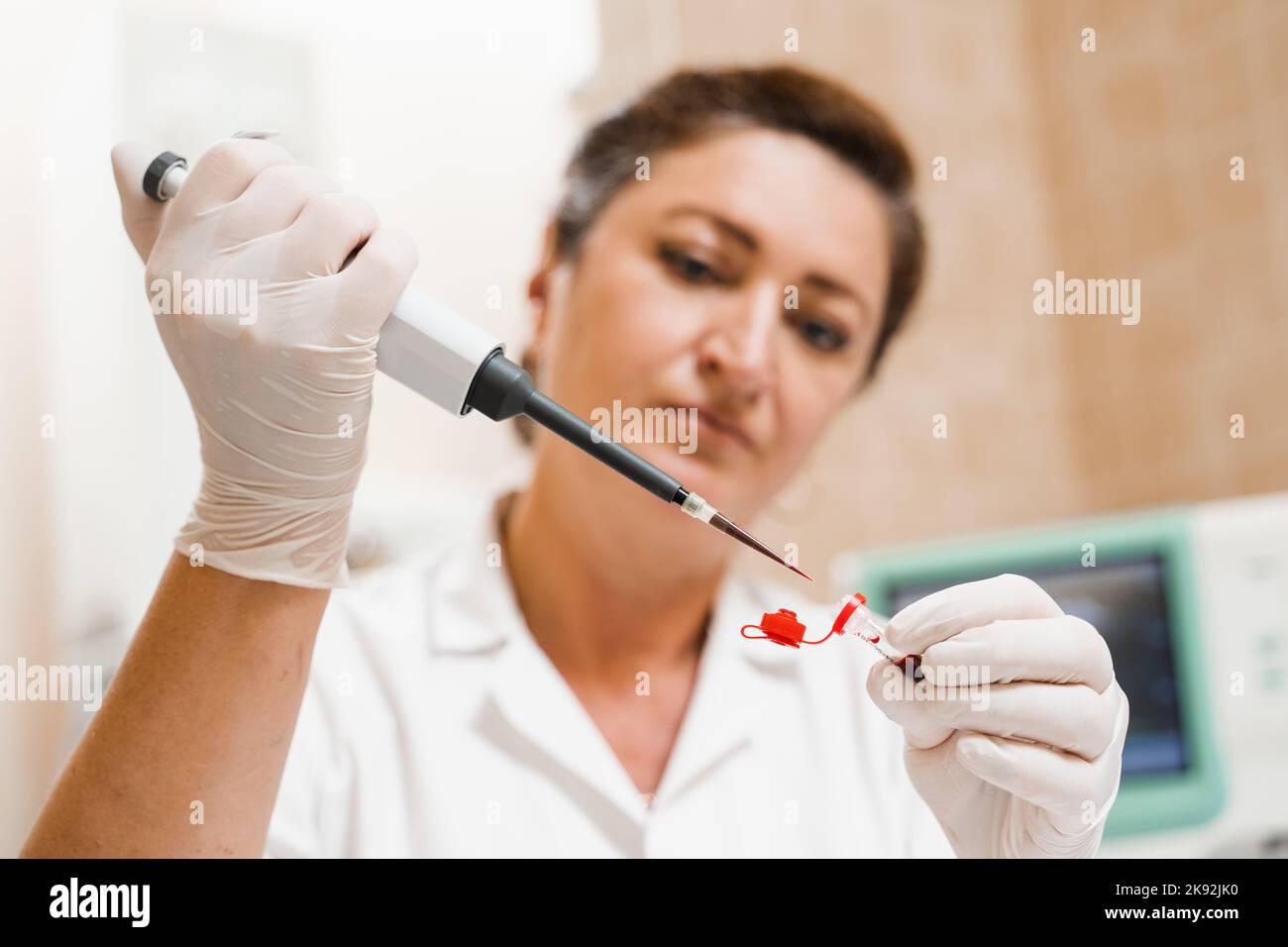 Laboratory assistant with dispenser in laboratory doing blood test ...