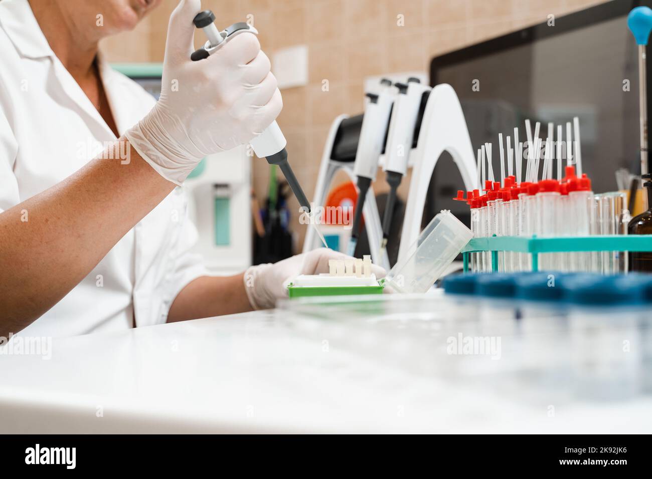 Laboratory assistant with dispenser in laboratory doing blood test ...