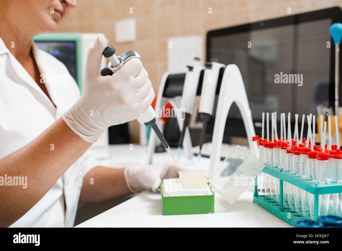 Laboratory assistant with dispenser in laboratory doing blood test ...