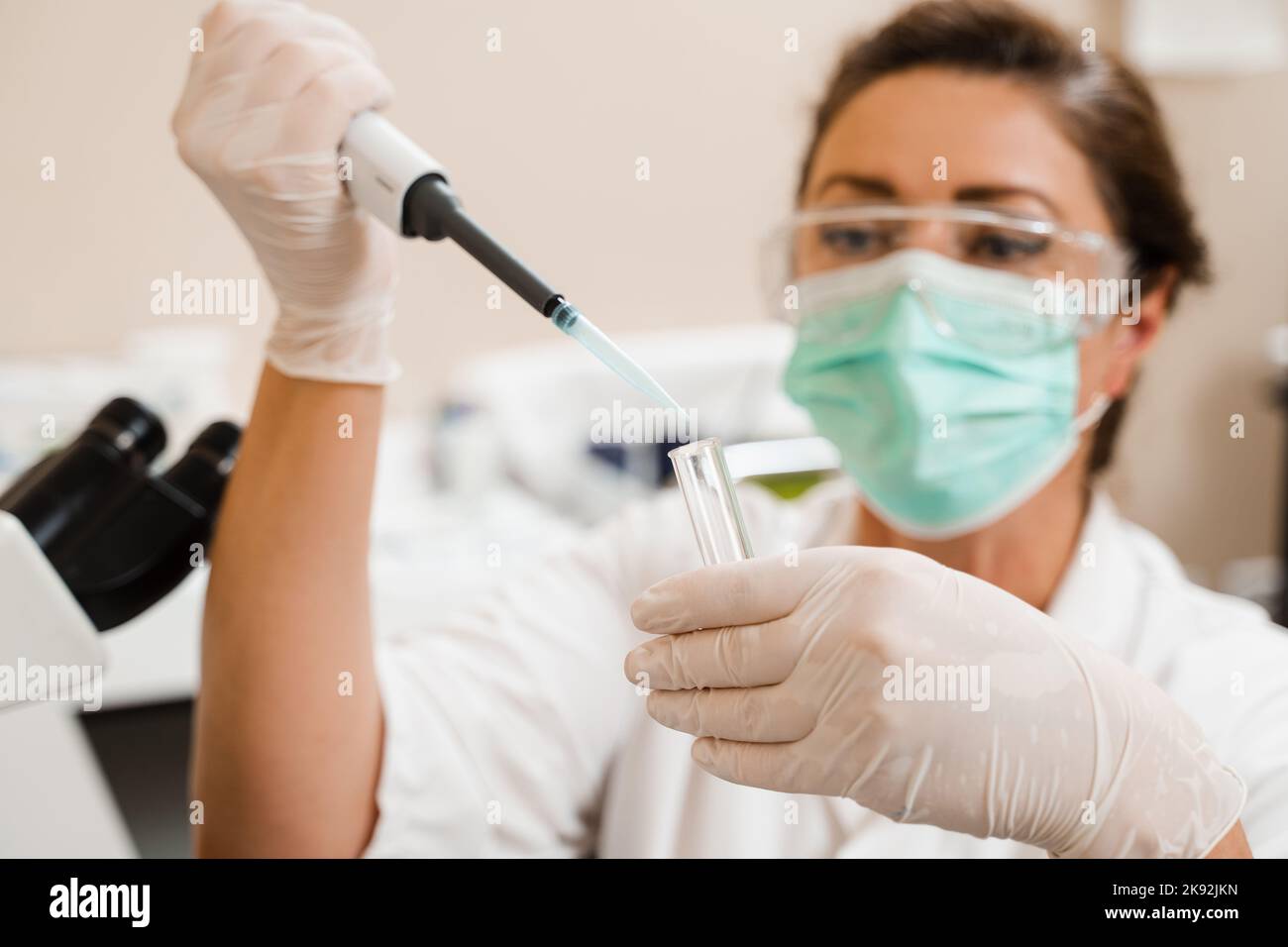 Laboratory assistant with dispenser in laboratory doing blood test ...