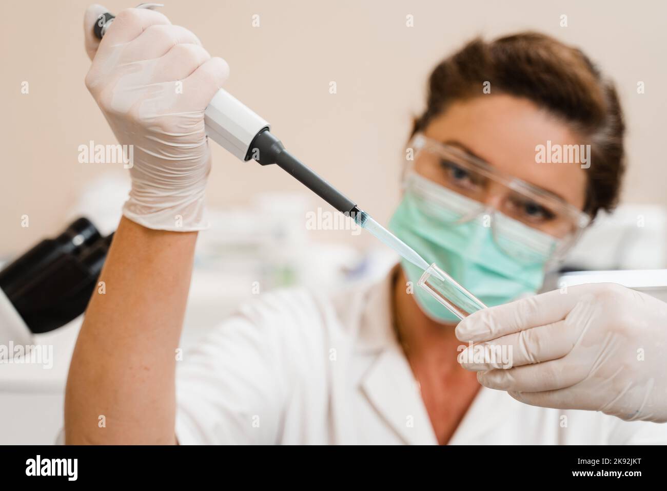 Laboratory assistant with dispenser in laboratory doing blood test ...