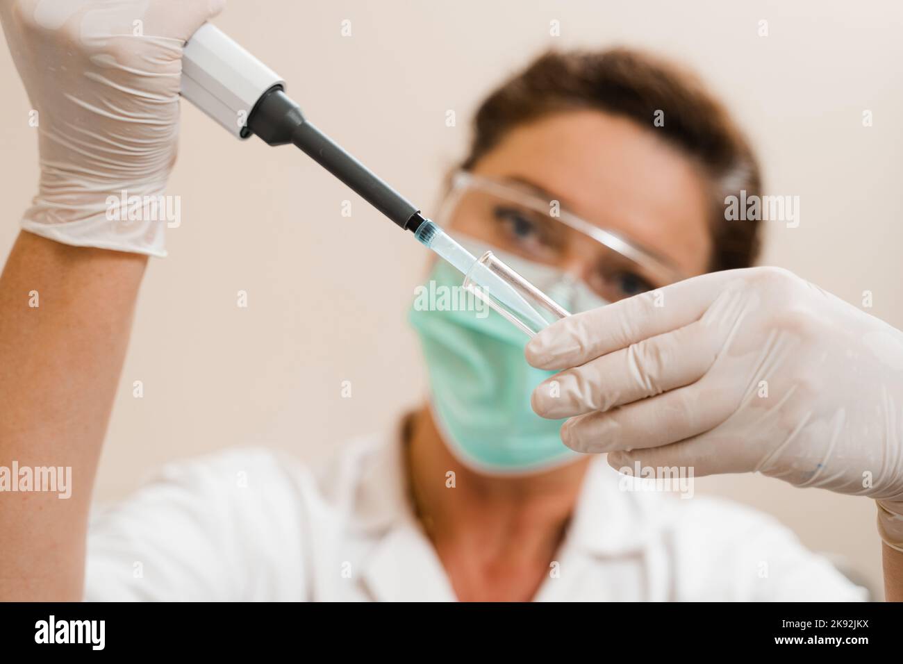 Laboratory assistant with dispenser in laboratory doing blood test ...