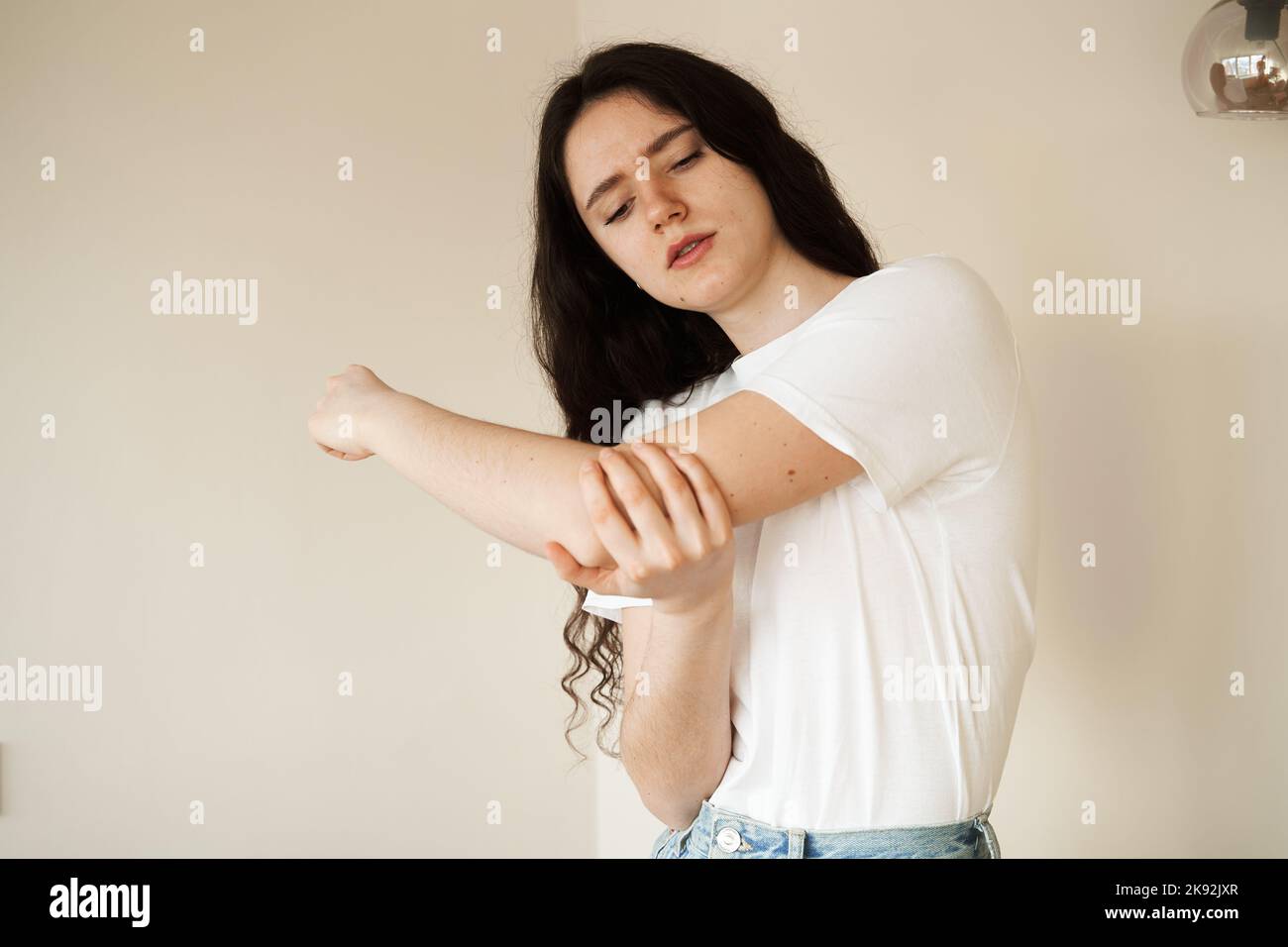 Elbow injury. Beautiful girl with pain and bruise in her arm due to an ...