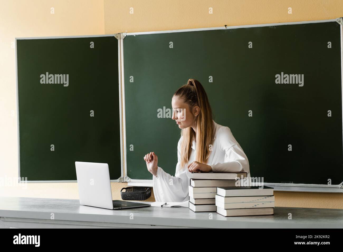 Education. Schoolgirl typing on laptop and study online at school board ...