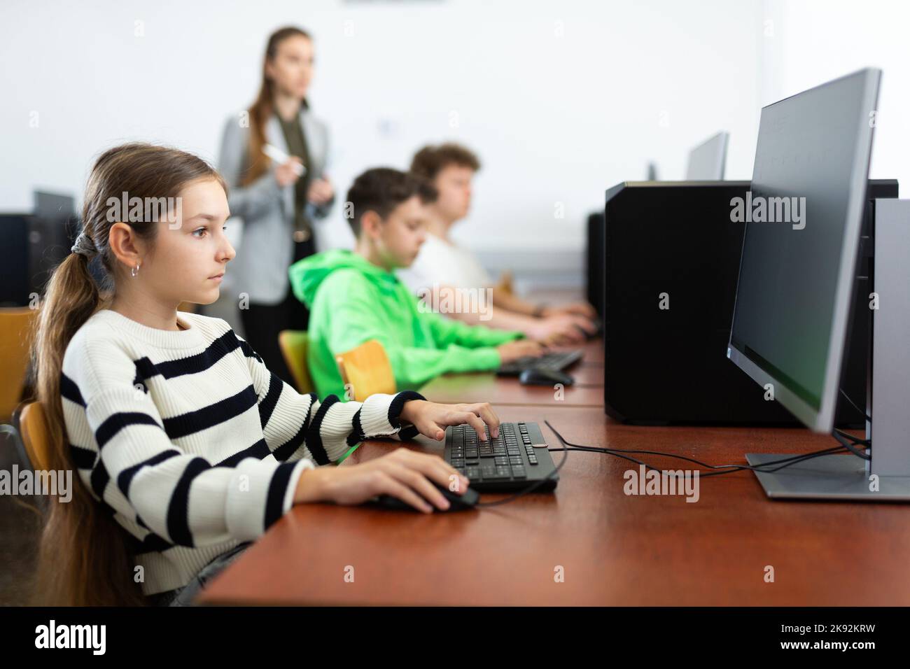 Young girl using computer during lesson Stock Photo - Alamy