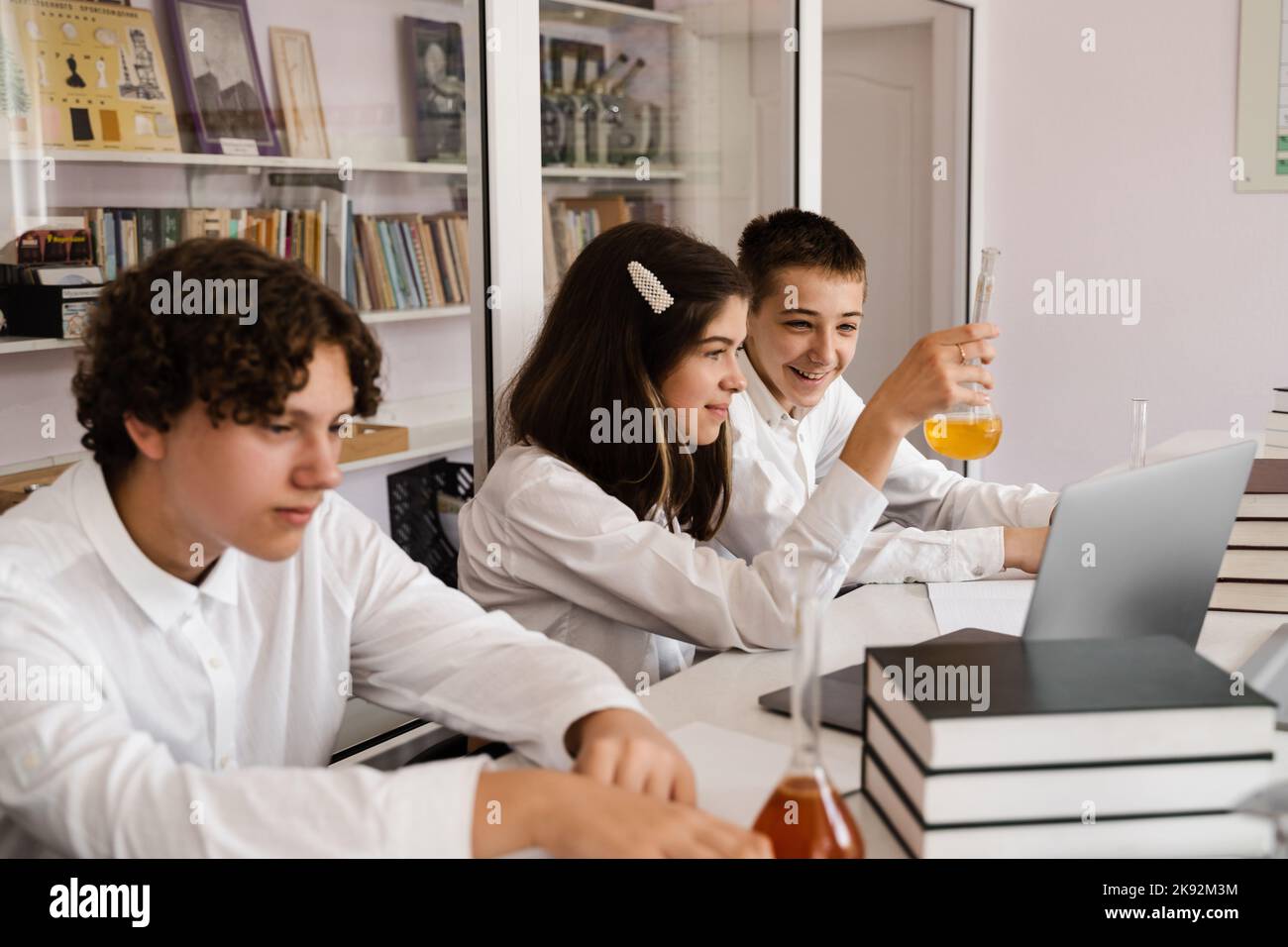 School education. Cheerful classmates in chemistry lesson hold flasks ...