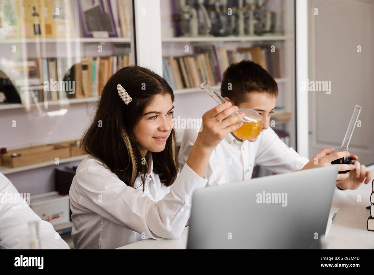 School education. Cheerful classmates in chemistry lesson hold flasks ...