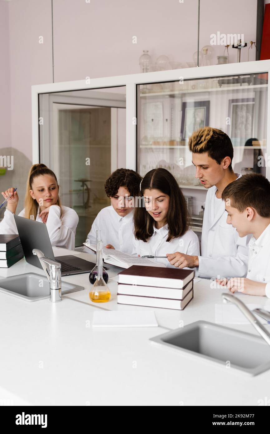 Education. Chemistry teacher helps explain theory in class at chemistry ...