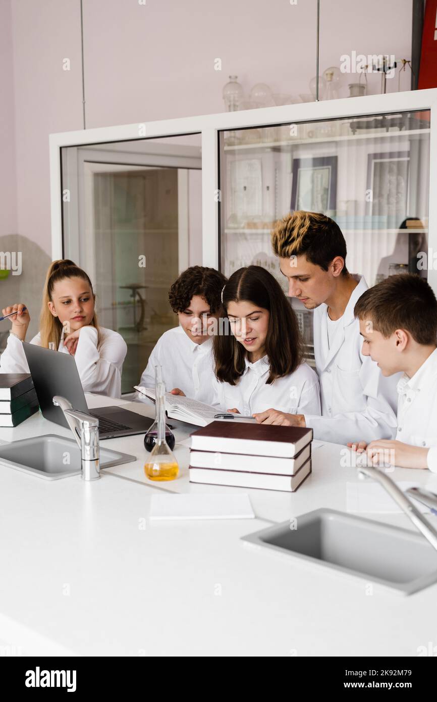 Education. Chemistry teacher helps explain theory in class at chemistry ...