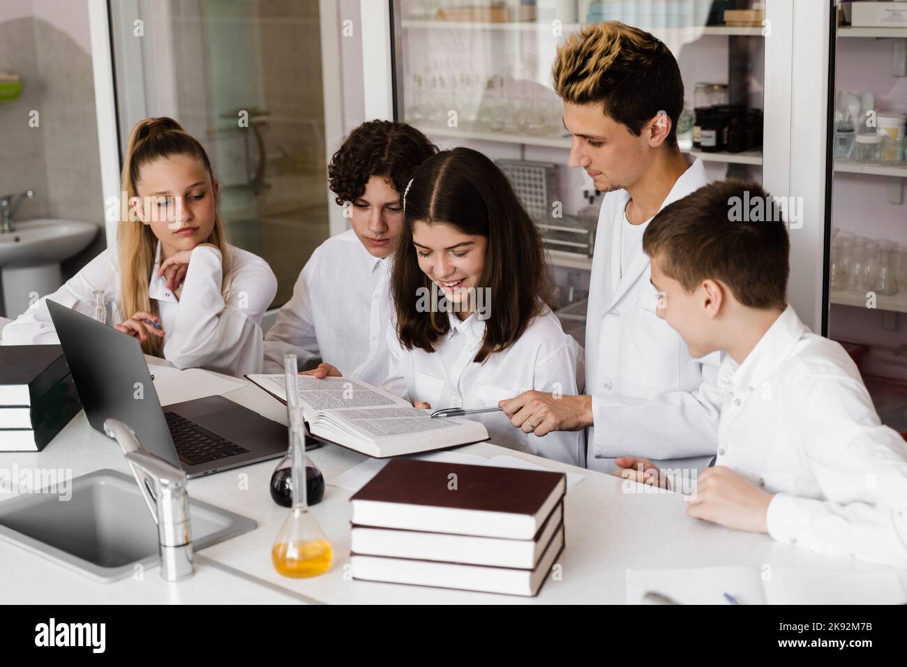 Education. Chemistry teacher helps explain theory in class at chemistry ...