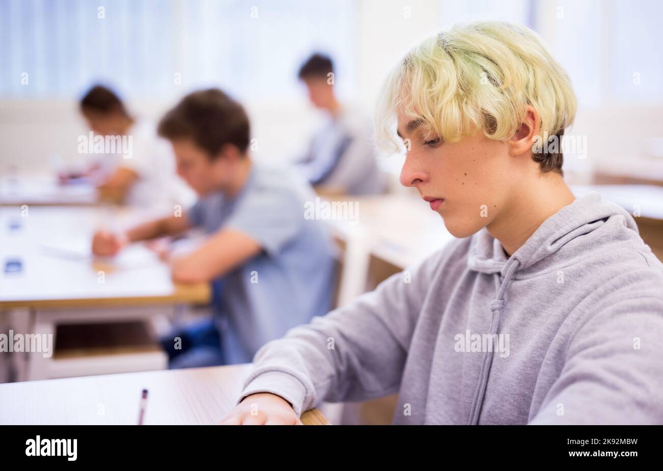 Focused teenage student writing lectures in classroom Stock Photo - Alamy