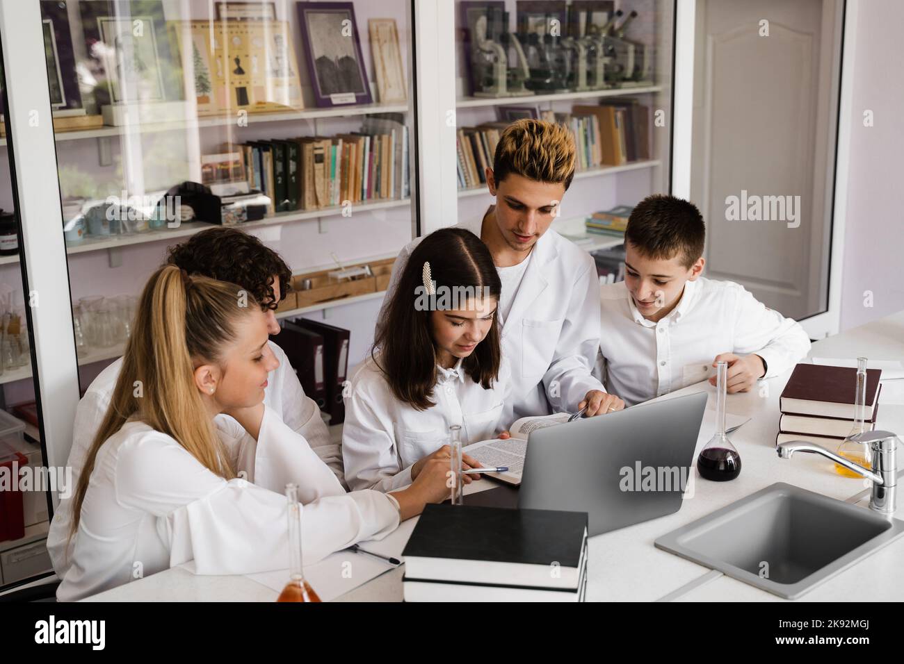 Education. Chemistry teacher helps explain theory in class at chemistry ...