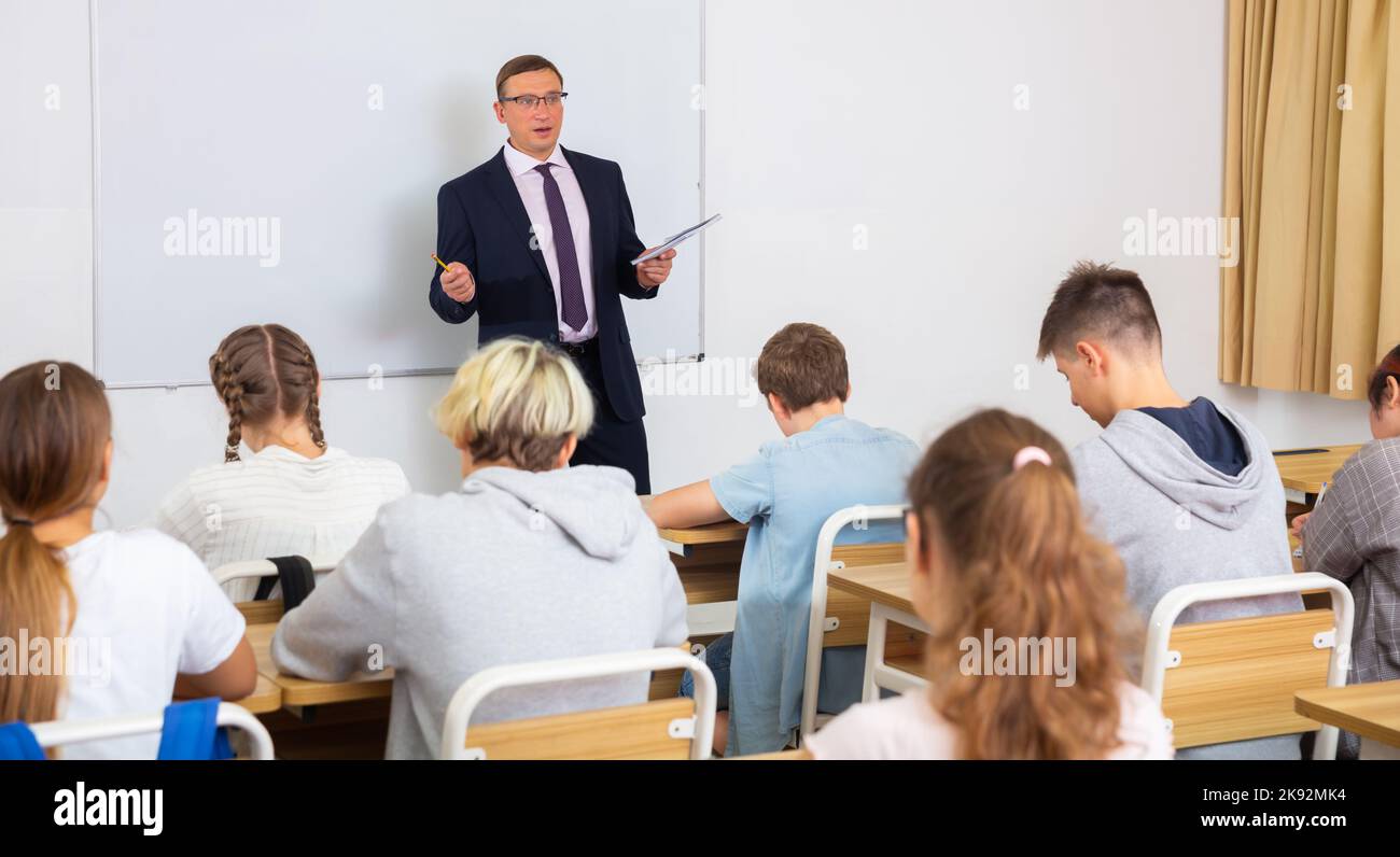 Male teacher lecturing to students at classroom Stock Photo - Alamy