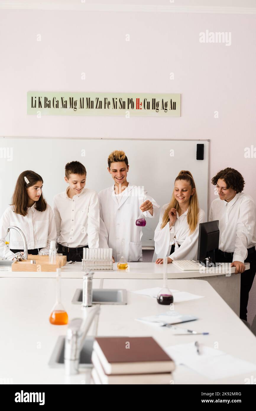 Discussion with a teacher at a chemistry lesson in a laboratory. Group ...