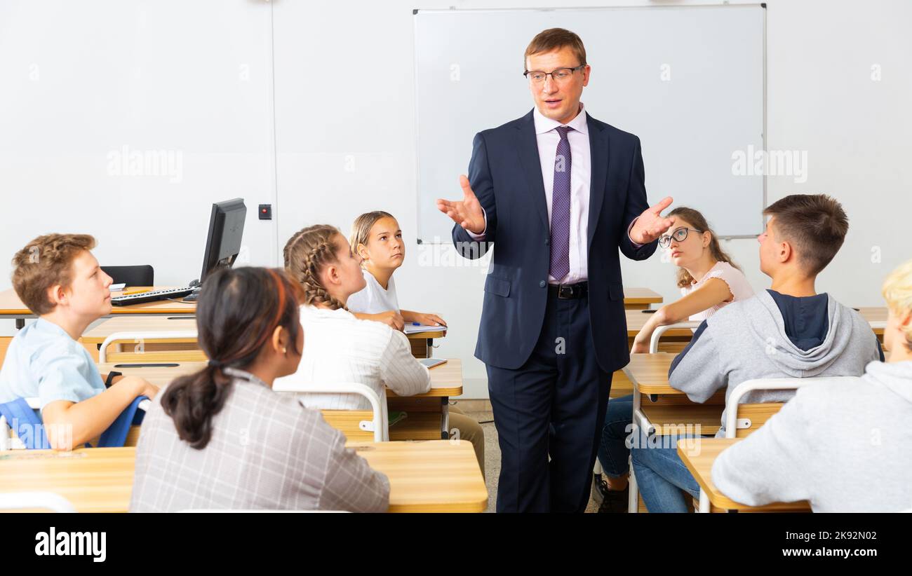 Male teacher lecturing to students at classroom Stock Photo - Alamy
