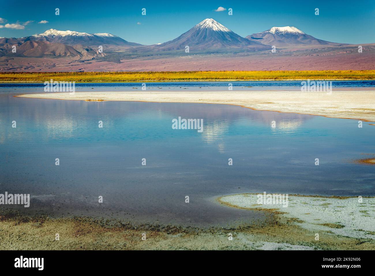 Volcanic landscape and salt lake reflection at sunset in Atacama Desert ...