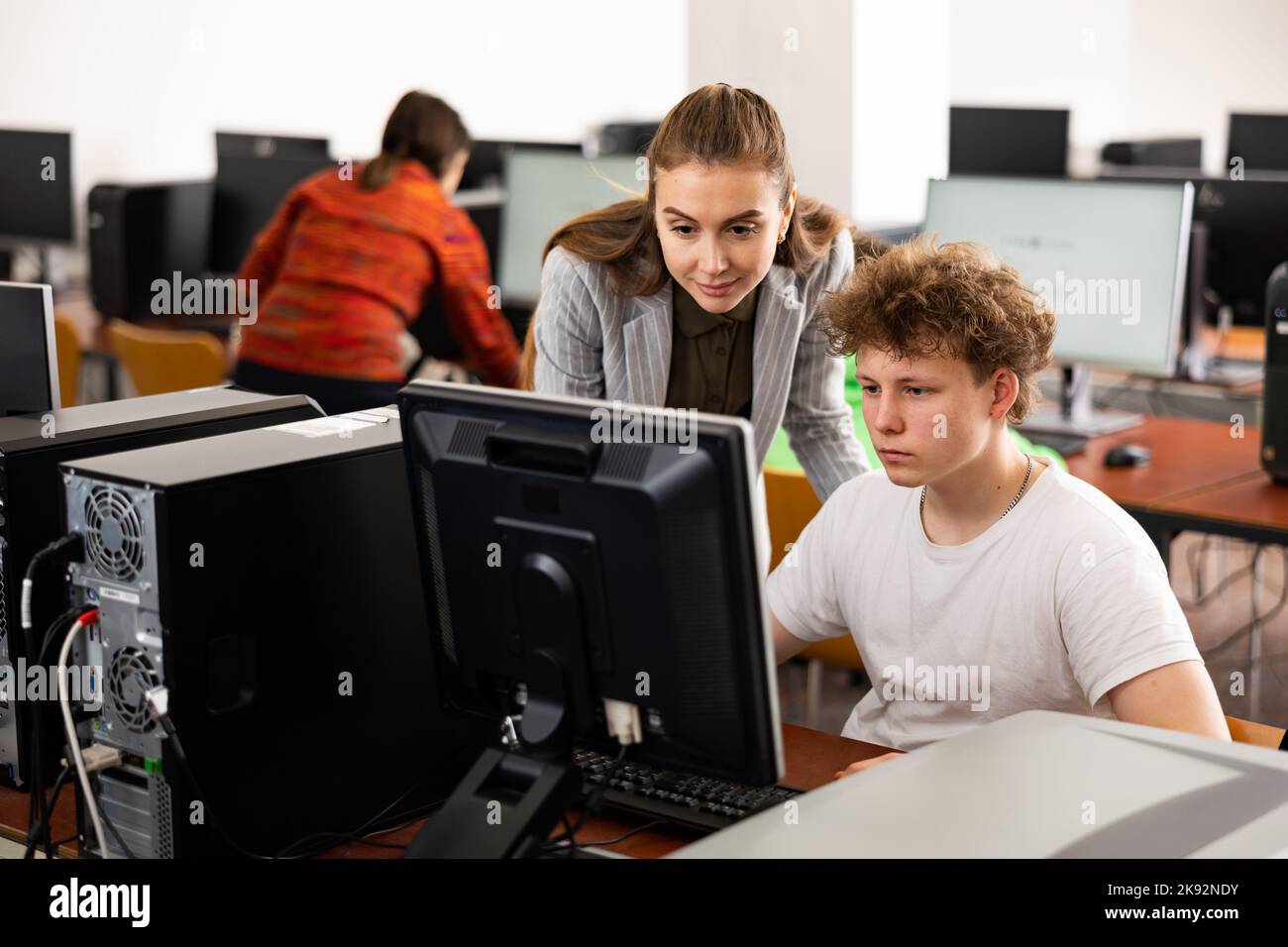 Teacher together with students conduct lesson on computer education ...