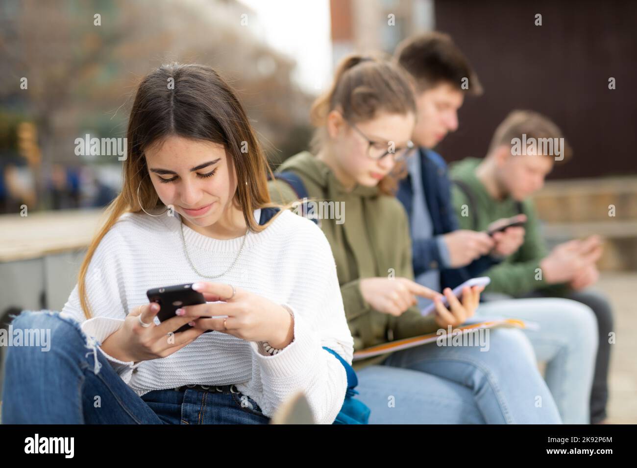Teenagers chatting on their smartphone on walking Stock Photo - Alamy