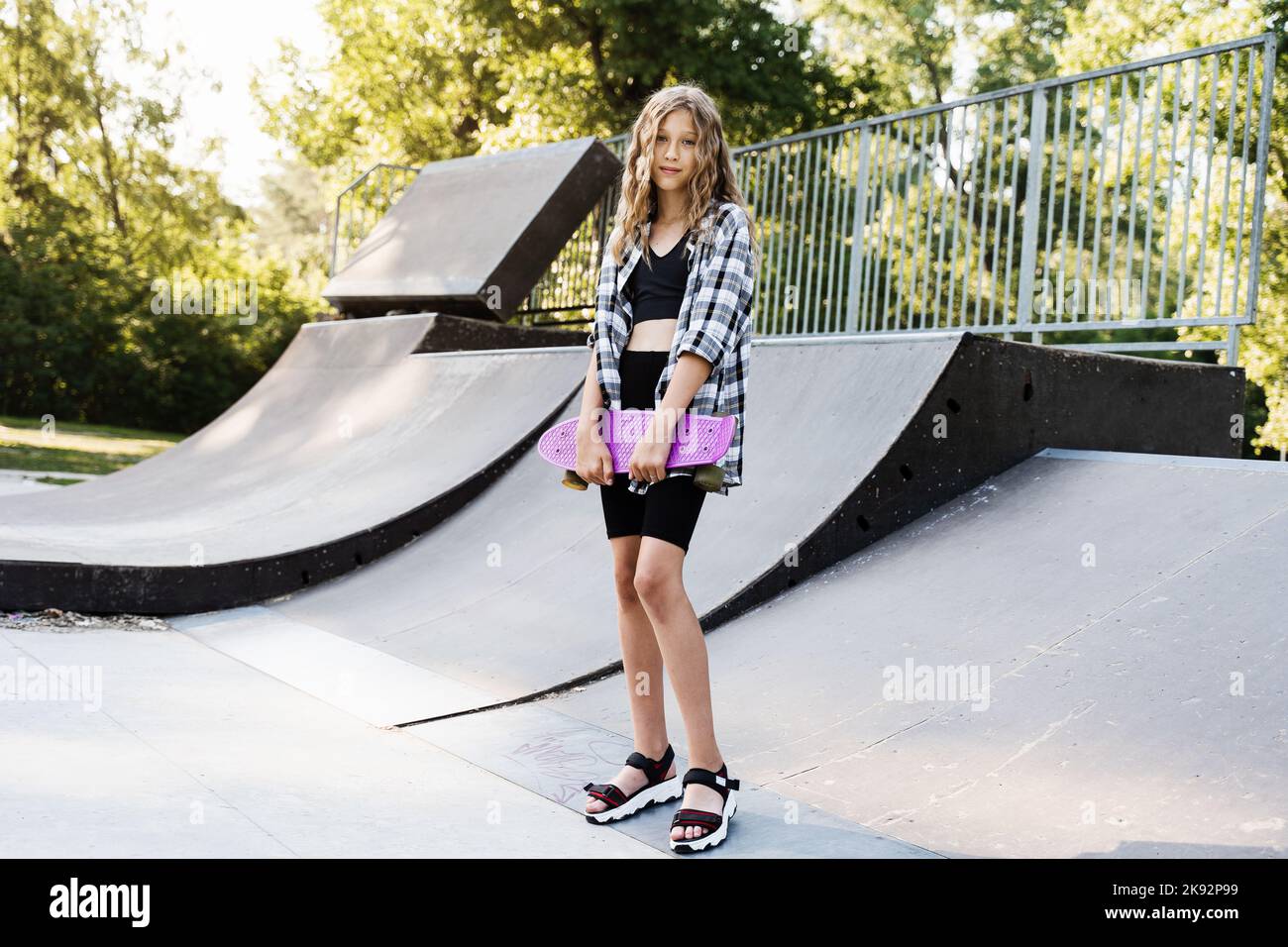 Child girl with penny board posing on skate sport ramp. Sports ...