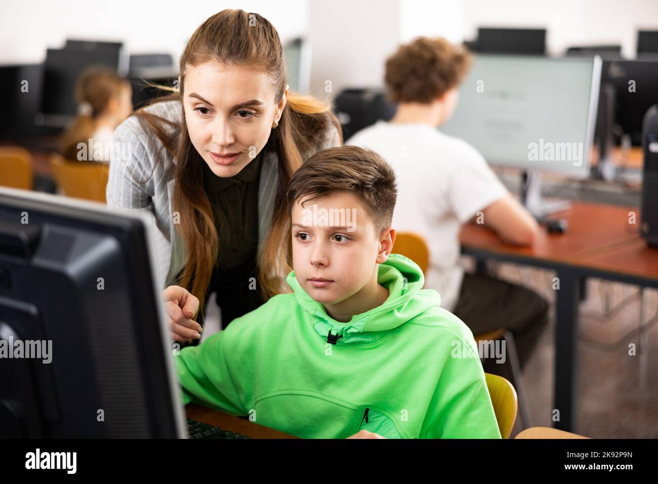 Teacher together with students conduct lesson on computer education ...