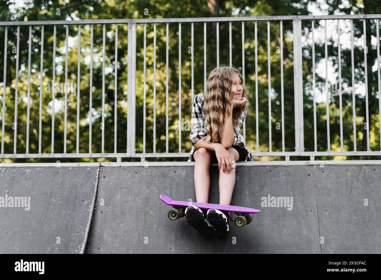 Active child with penny board sitting on skate sport ramp. Extreme ...