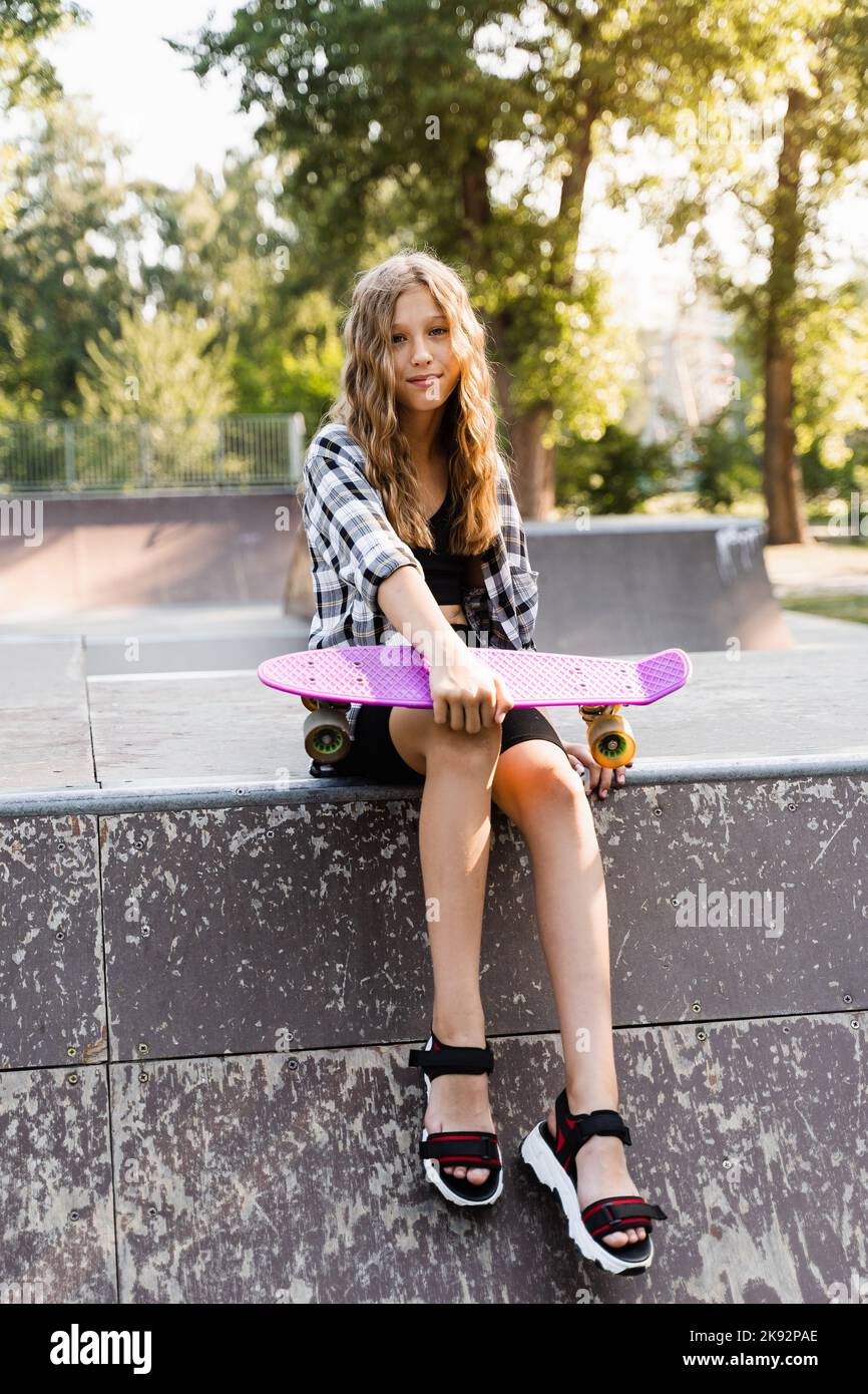 Extreme child girl with penny board in her hands on skate playground ...