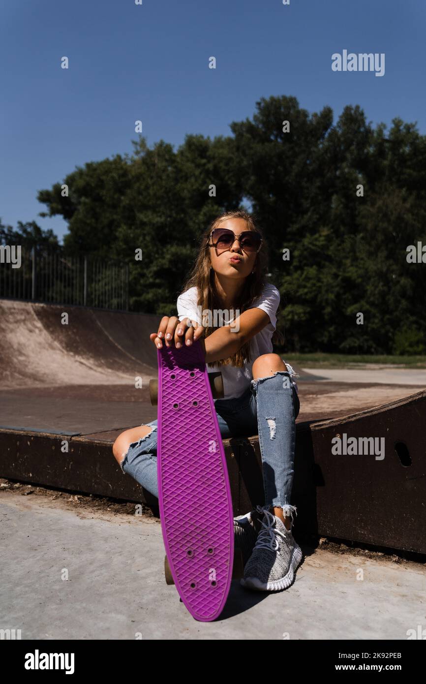 Active child with penny board sitting on skate sport ramp. Extreme ...