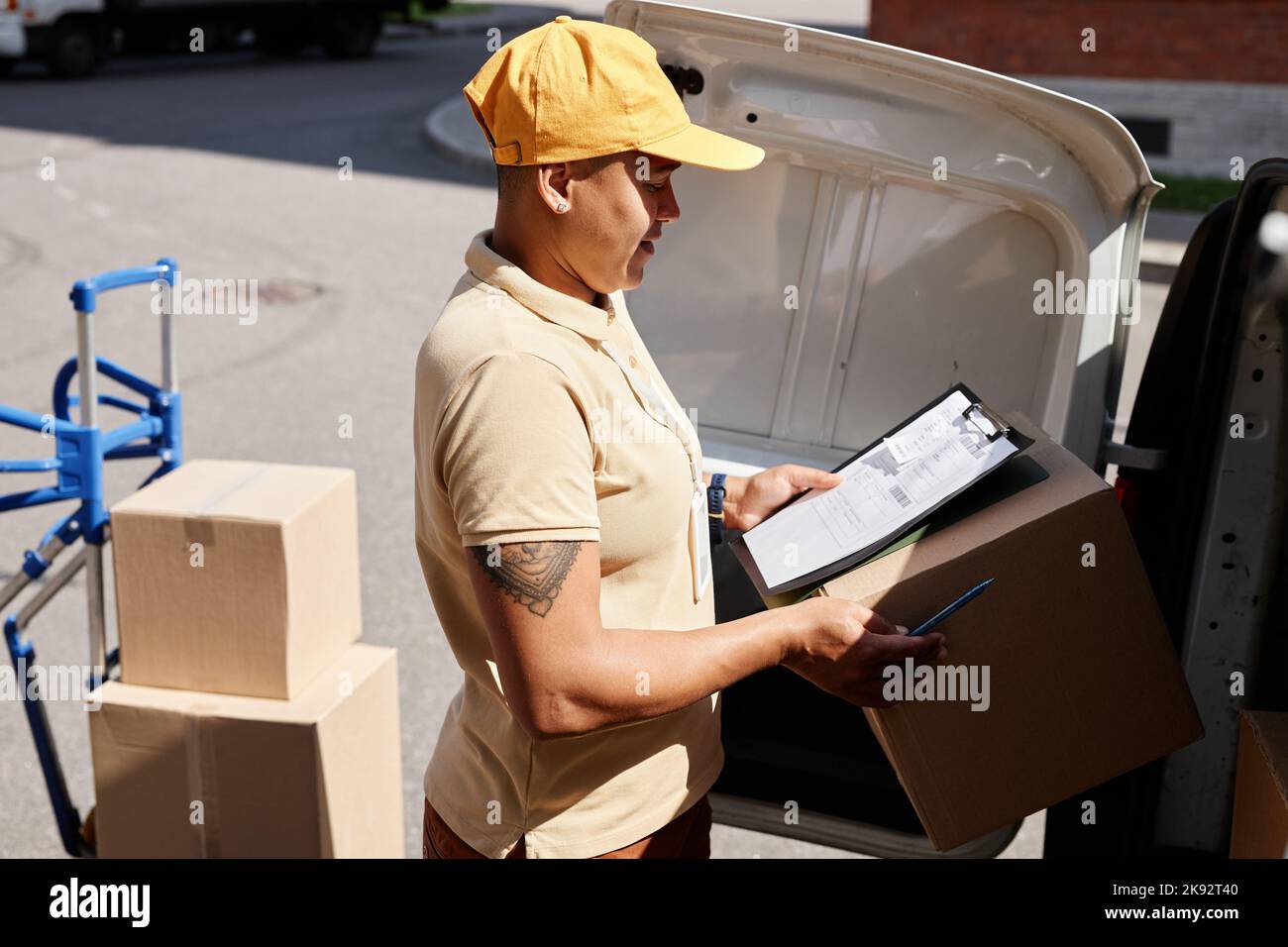 Side view portrait of multiethnic young woman unloading van with ...