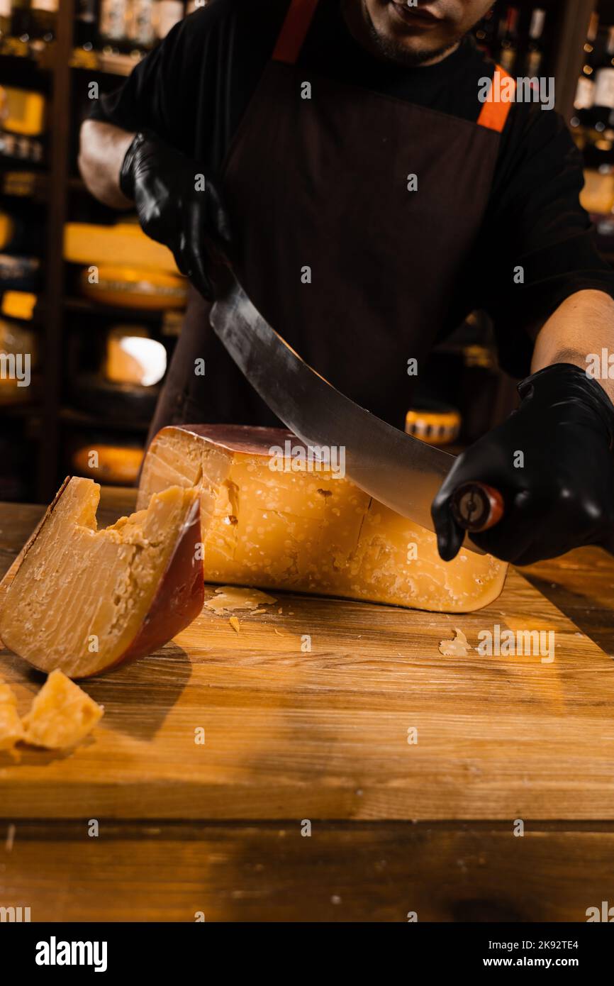 Cheese sommelier cutting limited gouda cheese with knife. Snack tasty ...