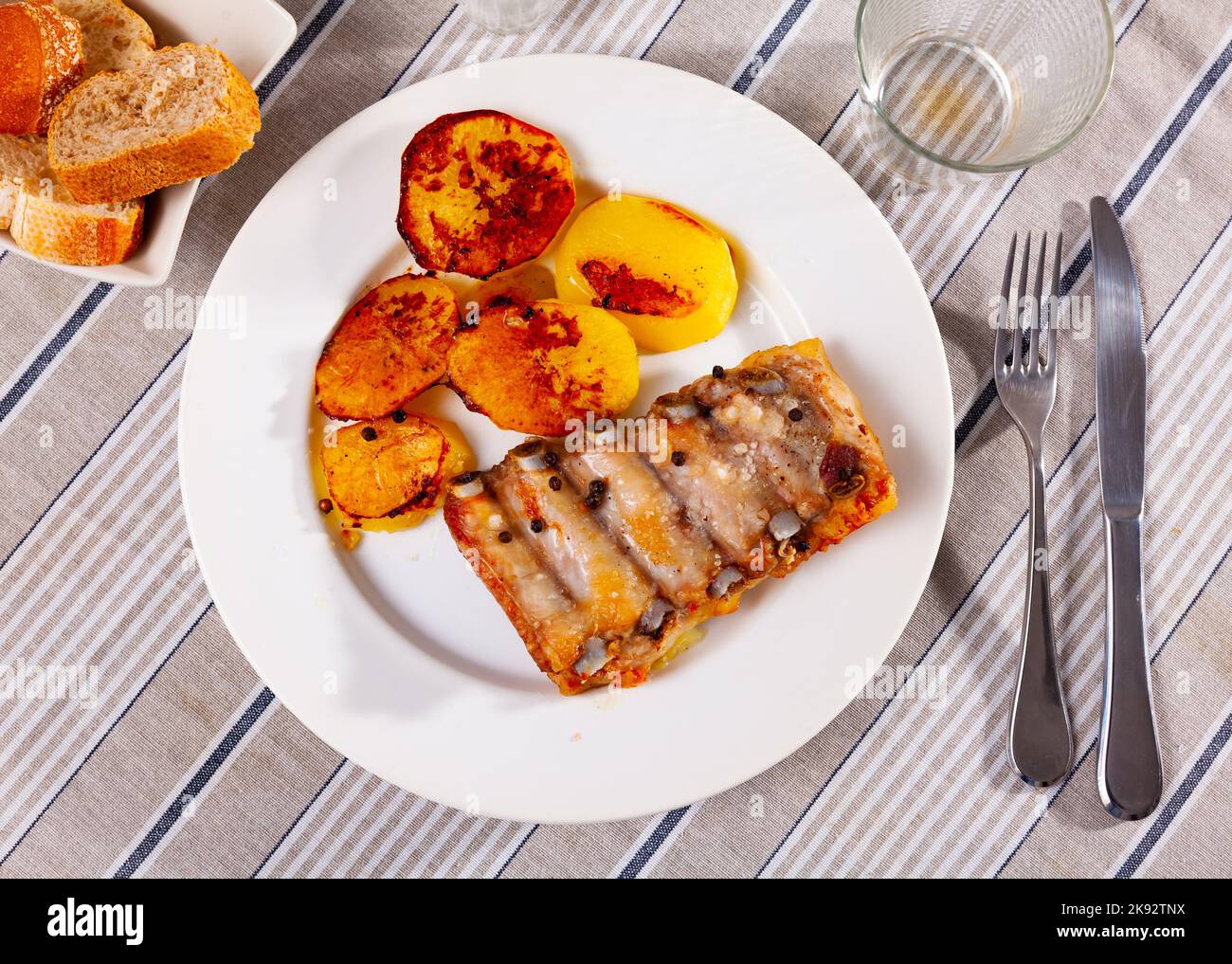 Appetizing baked pork ribs with fried sliced potatoes Stock Photo - Alamy
