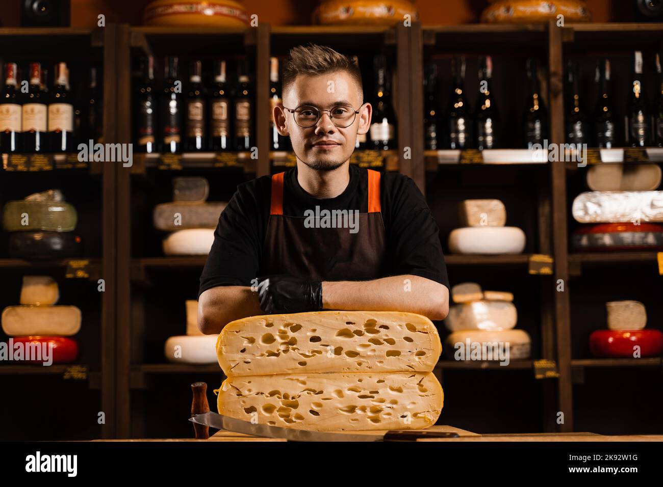 Professional cheese sommelier in food shop. Worker of cheese store with ...