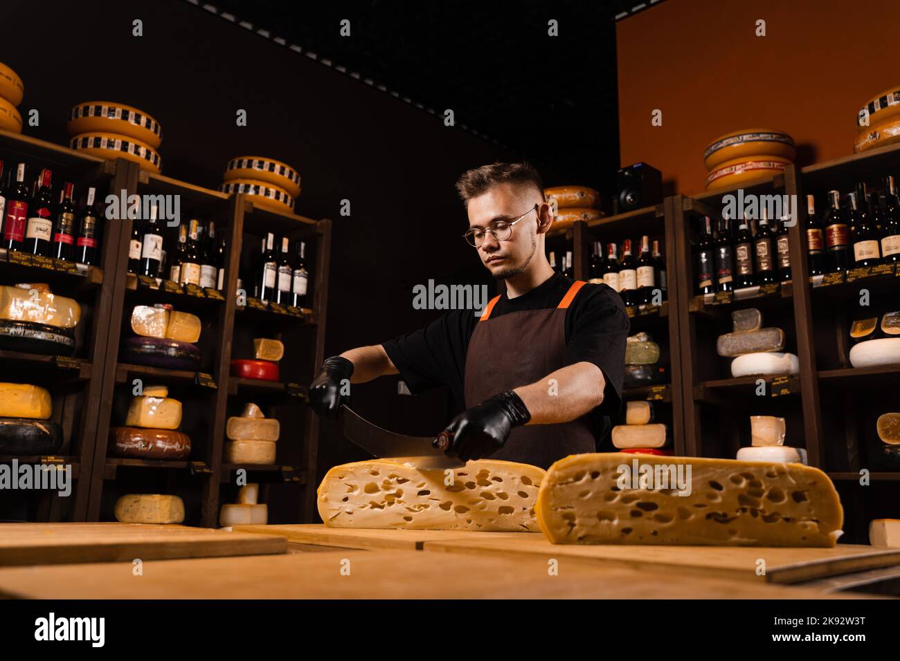 Handsome man worker of cheese shop cut limited maasdam natural aged ...