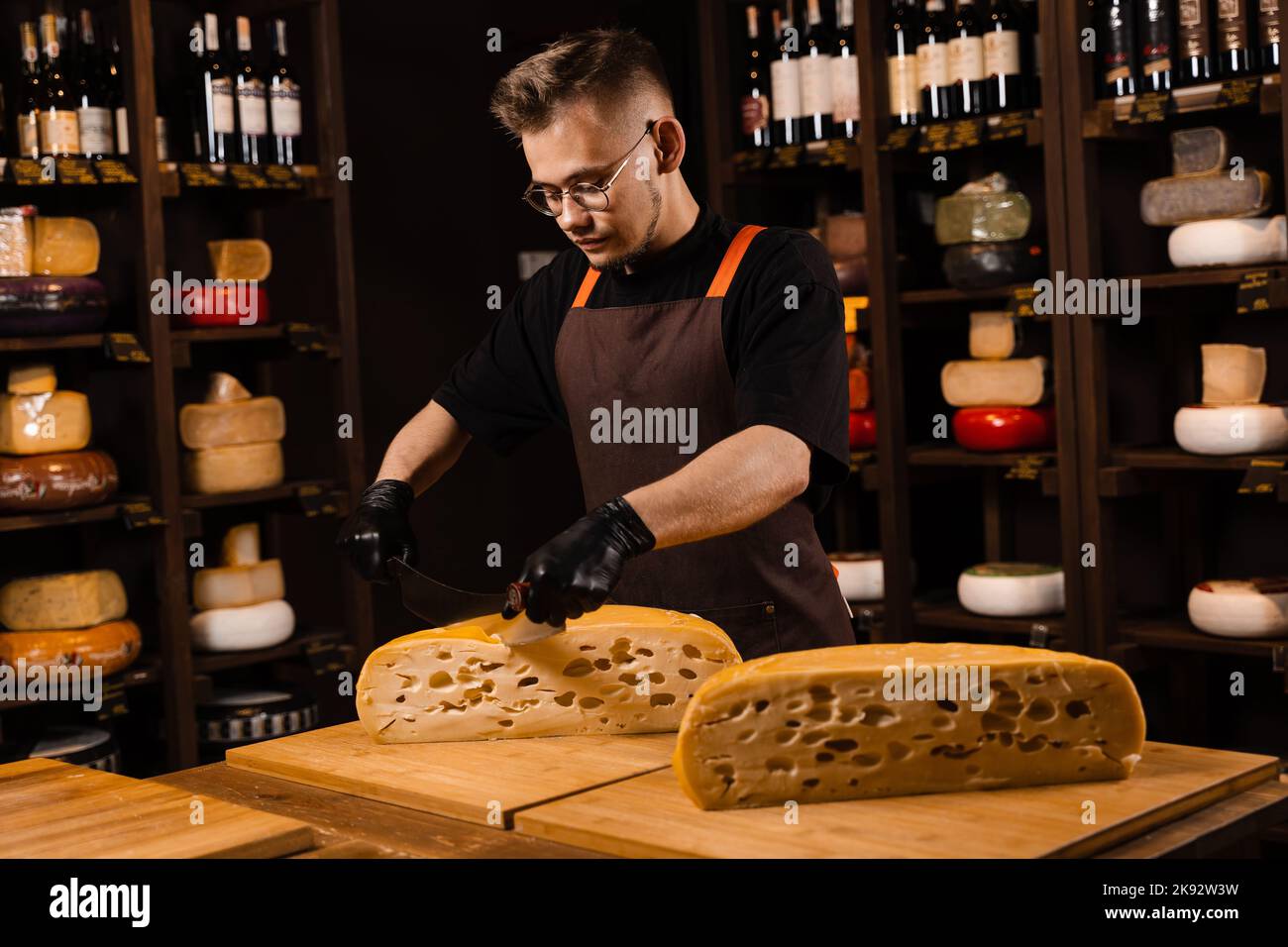 Limited maasdam cheese wheel cutting cheese in store. Cheese sommelier ...
