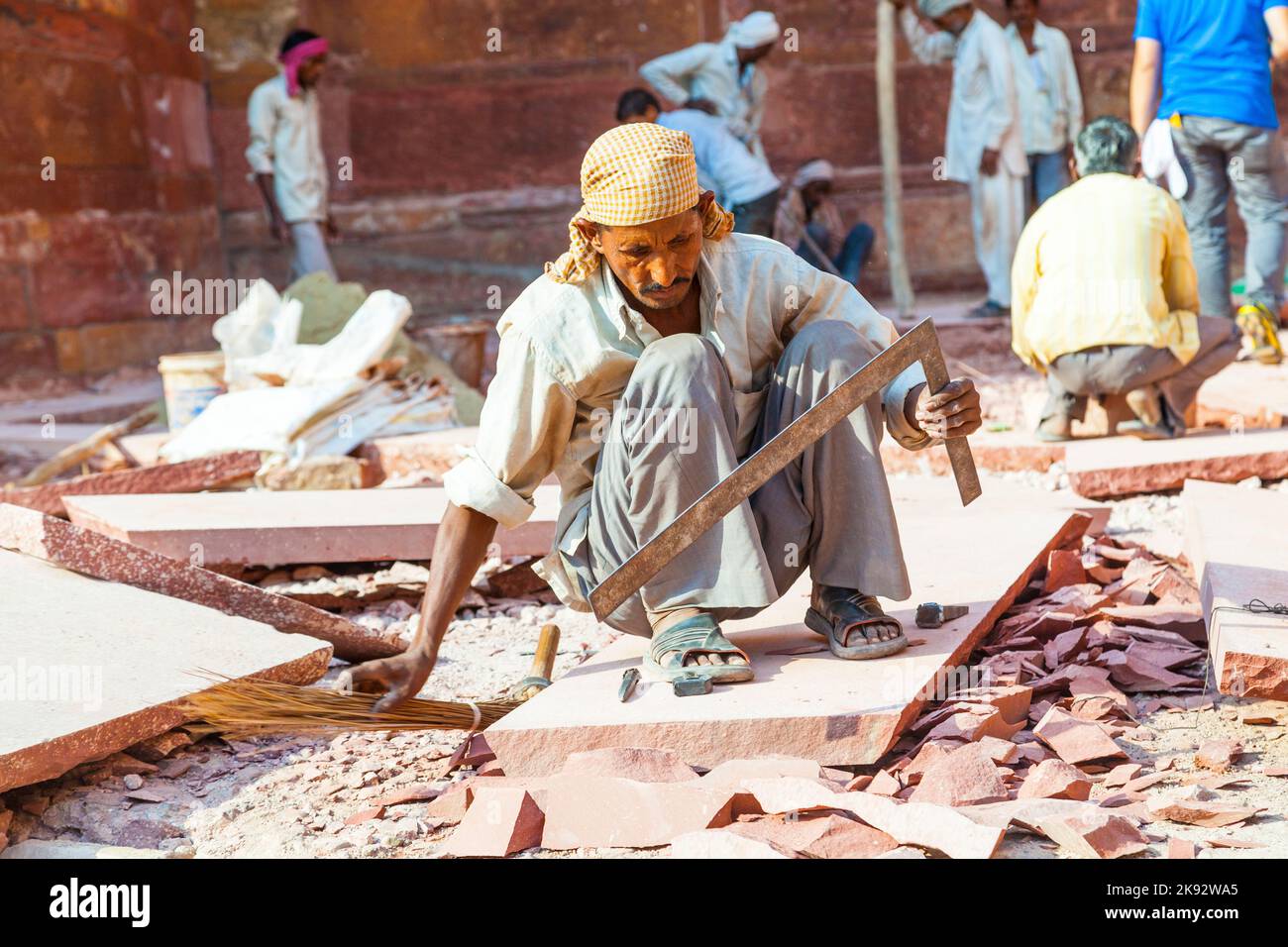 AGRA, INDIA - OCT 17, 2012: worker prepares sandstones for renovation ...