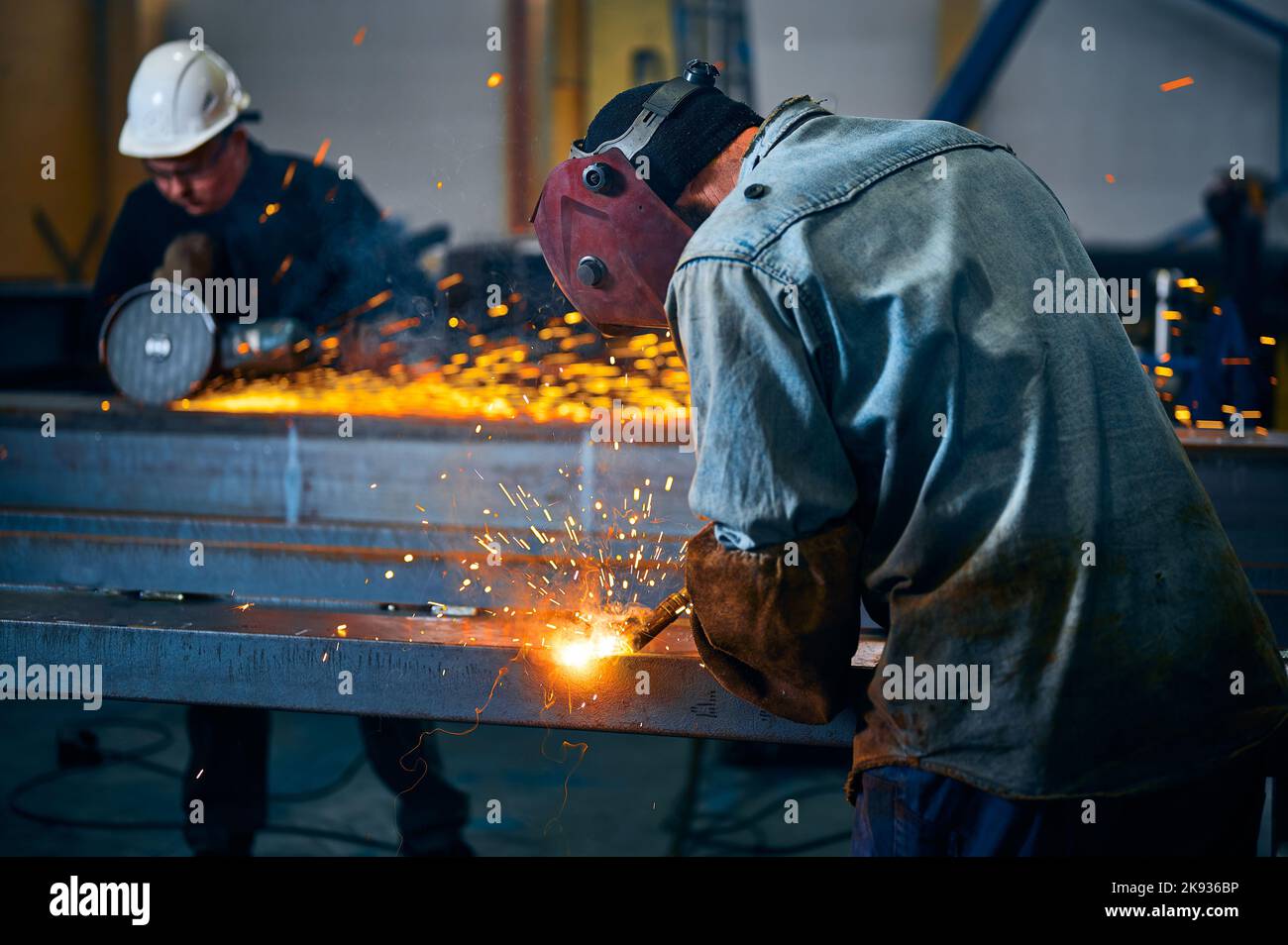 Worker with mask welds metal carcass parts in workshop Stock Photo - Alamy