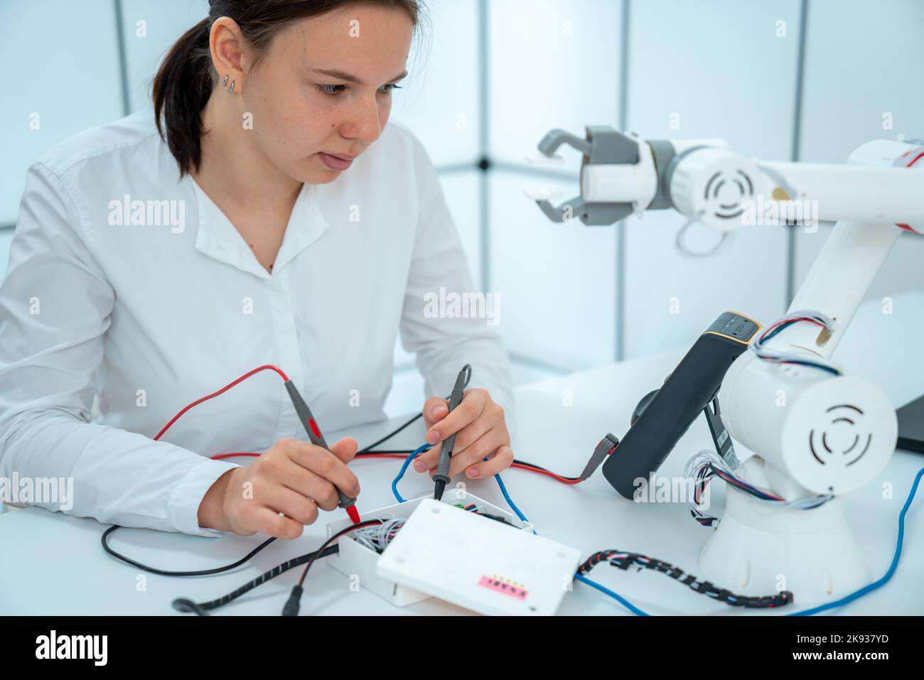 female student of the Technical University explores an industrial robot ...