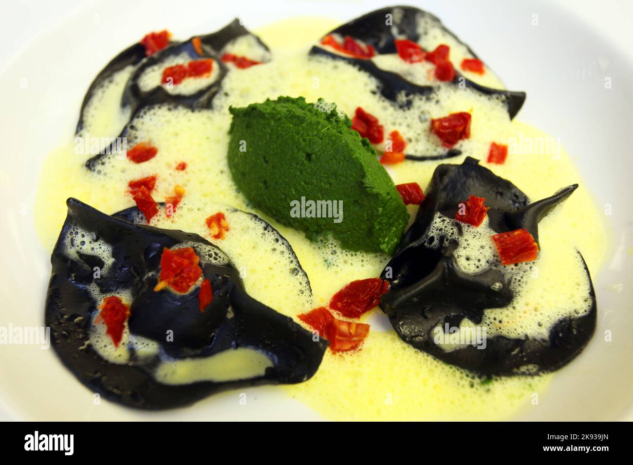 Black Squid Ink Ravioli with sauce on the dinner plate Stock Photo - Alamy