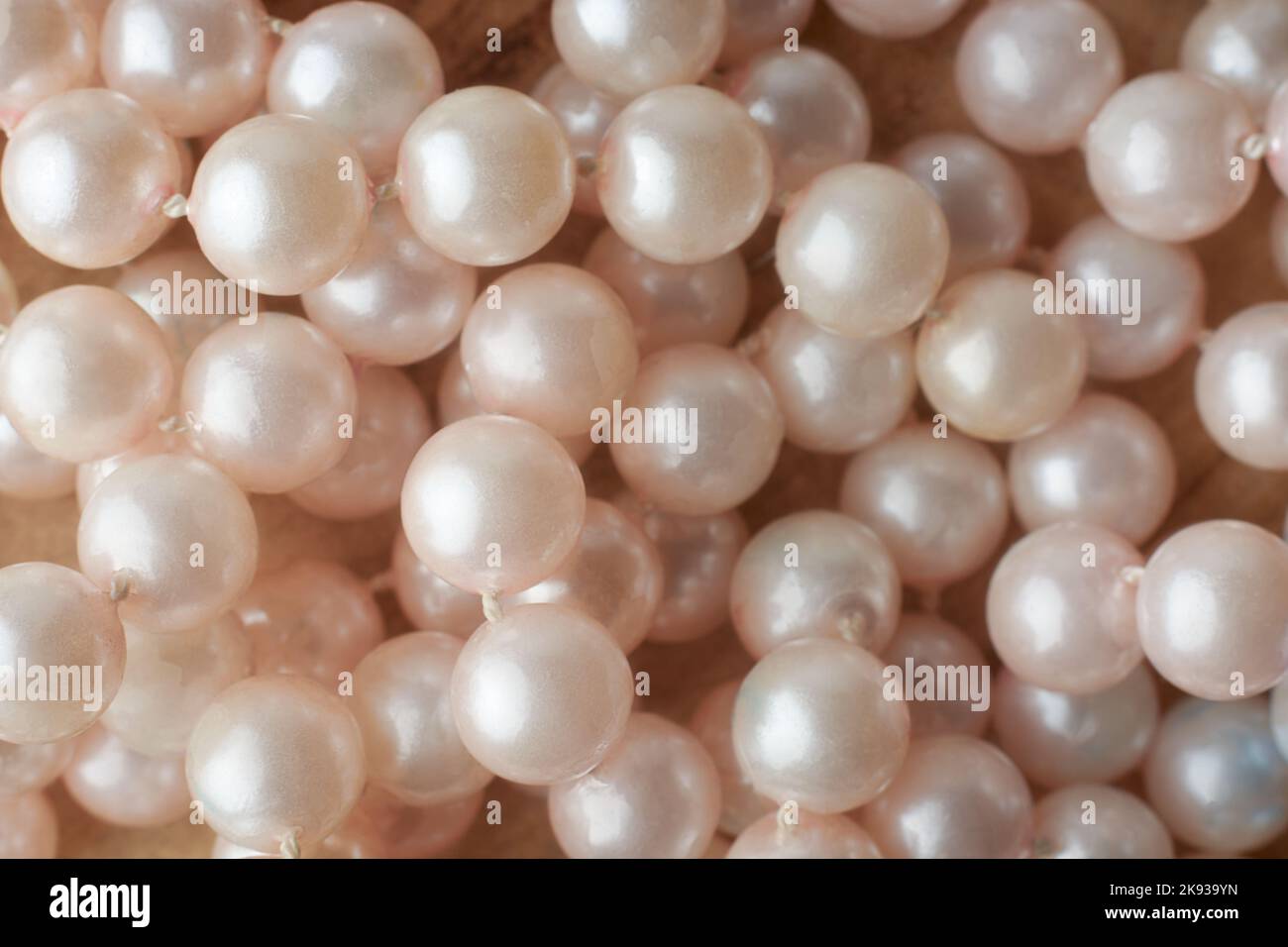 close-up of light pink color string of pearls, taken in soft focus ...