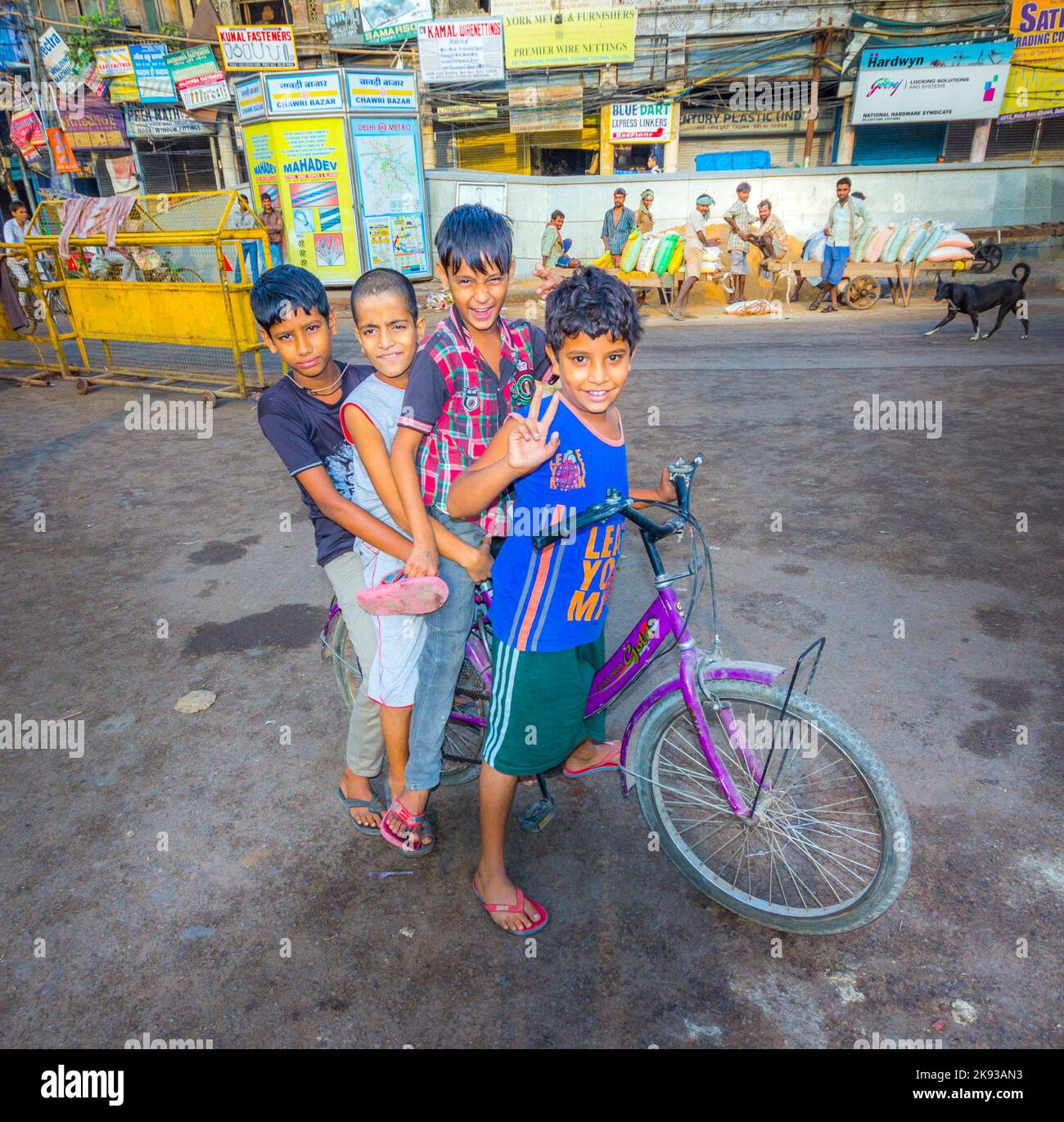 DELHI, INDIA - OCT 16, 2012: four children sit on a bike early morning ...