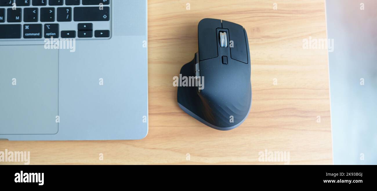 Ergonomic vertical mouse with laptop computer on adjustable desk at ...
