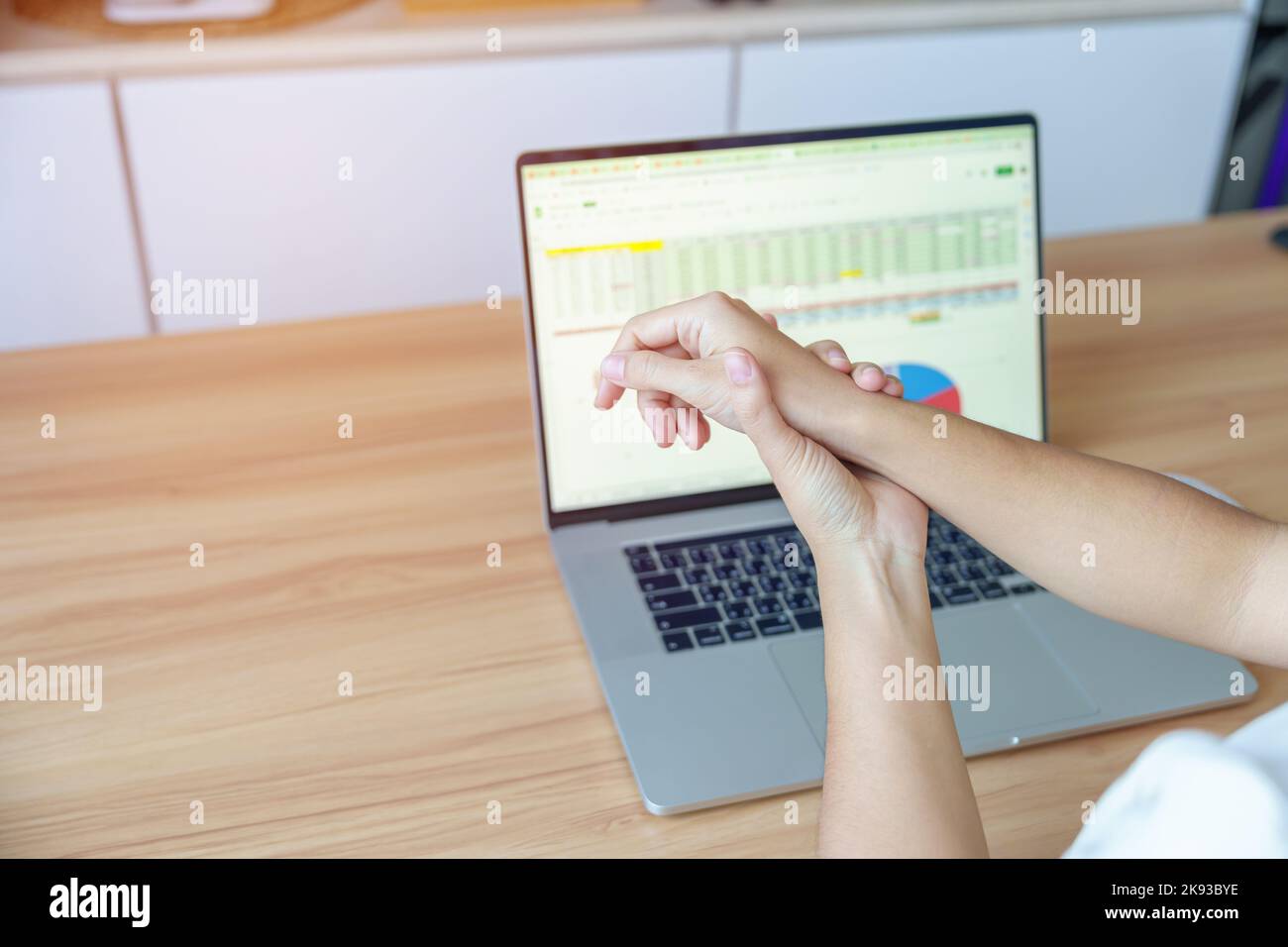 Woman having wrist pain when using laptop computer and mouse during ...