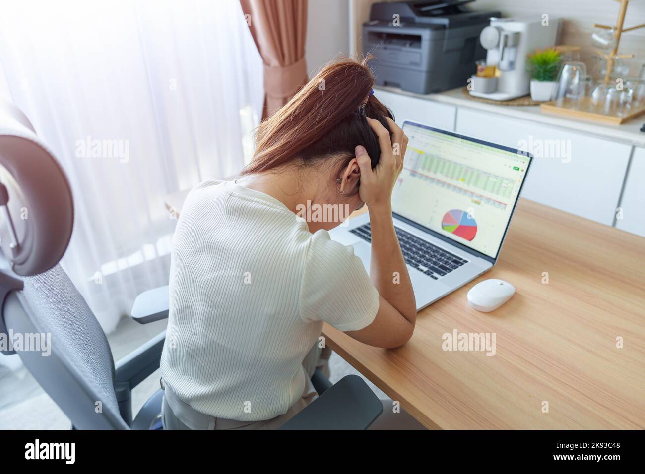 Woman having headache during using laptop computer on workplace ...