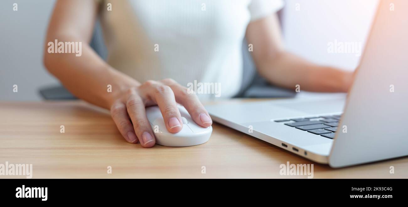 Woman using mouse and laptop computer during working long time on ...