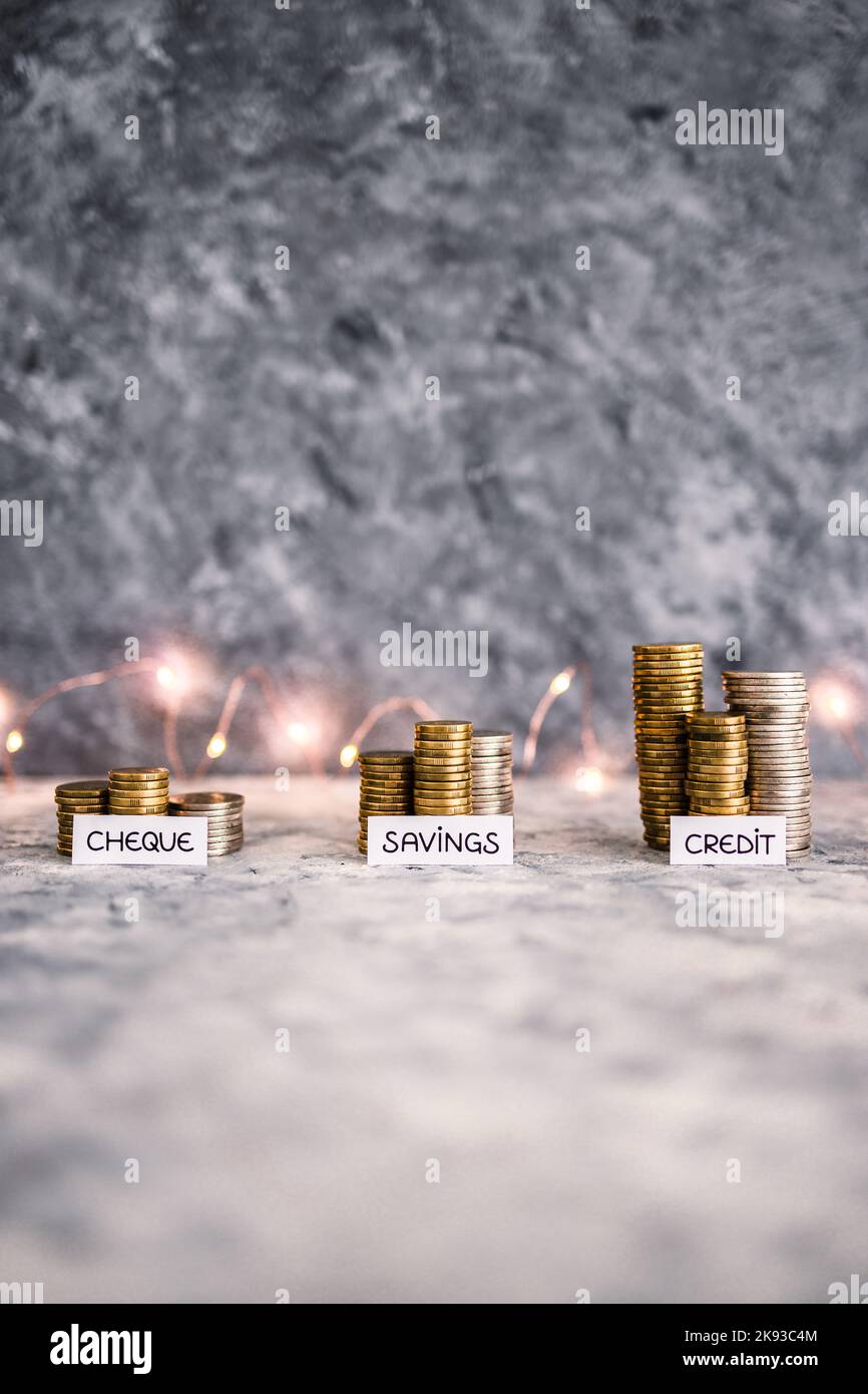 Cheque savings and credit account texts in front of growing stacks of ...