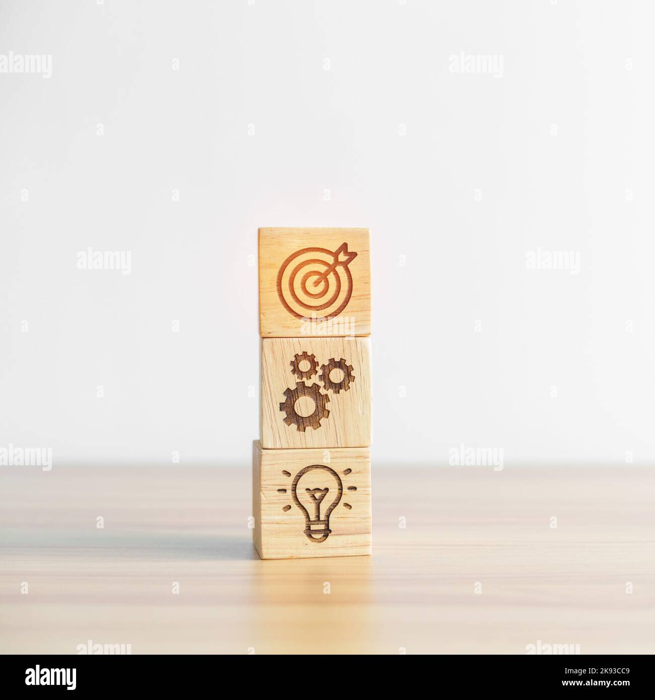 dartboard above Gear and Lightbulb icon block on desk. business ...