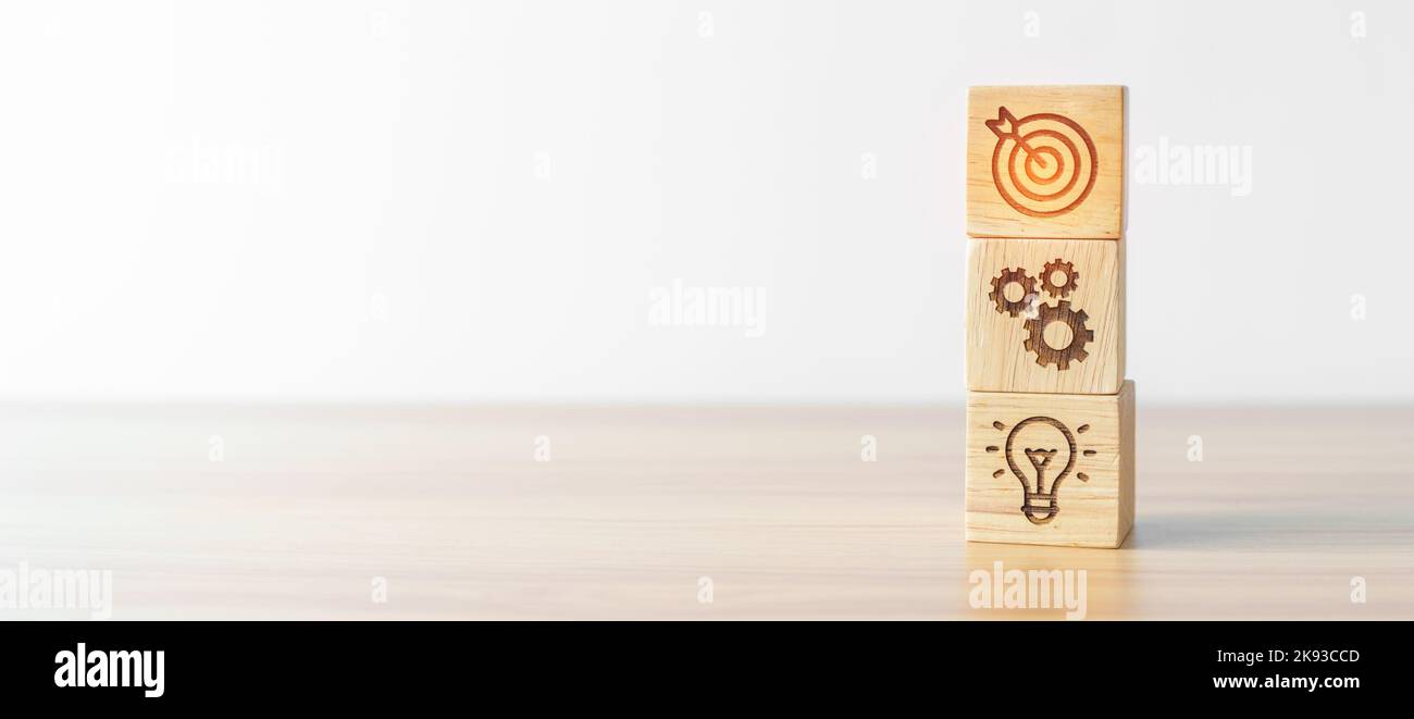 dartboard above Gear and Lightbulb icon block on desk. business ...