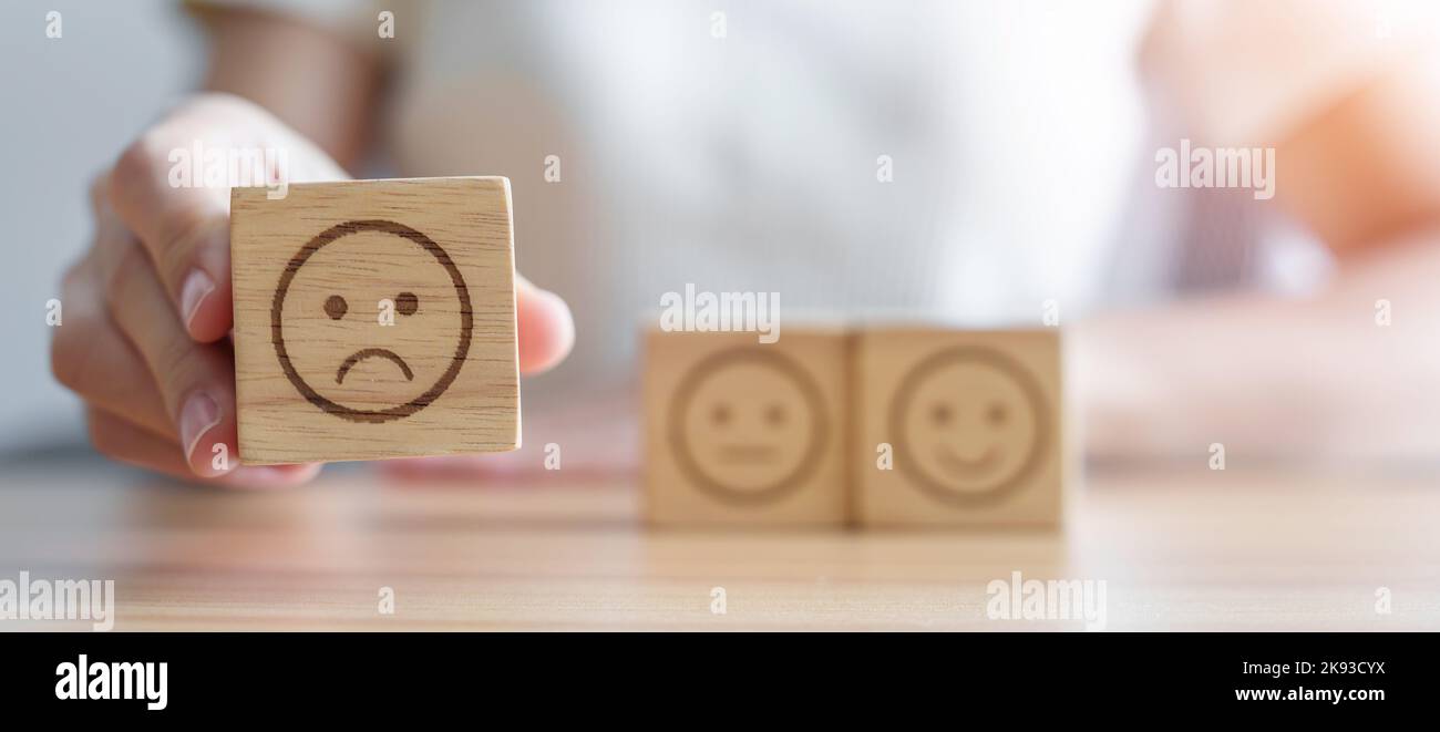 Hand choosing unhappy angry face from Emotion block. customer review ...