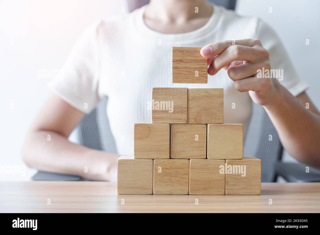 Woman hand placing wood block on the building. Leadership, Business ...